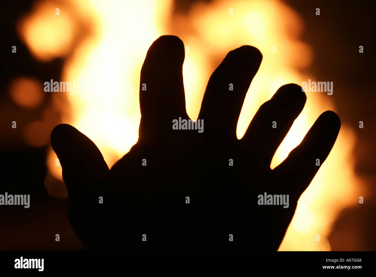 Hand silhouetted by fire flames Stock Photo - Alamy