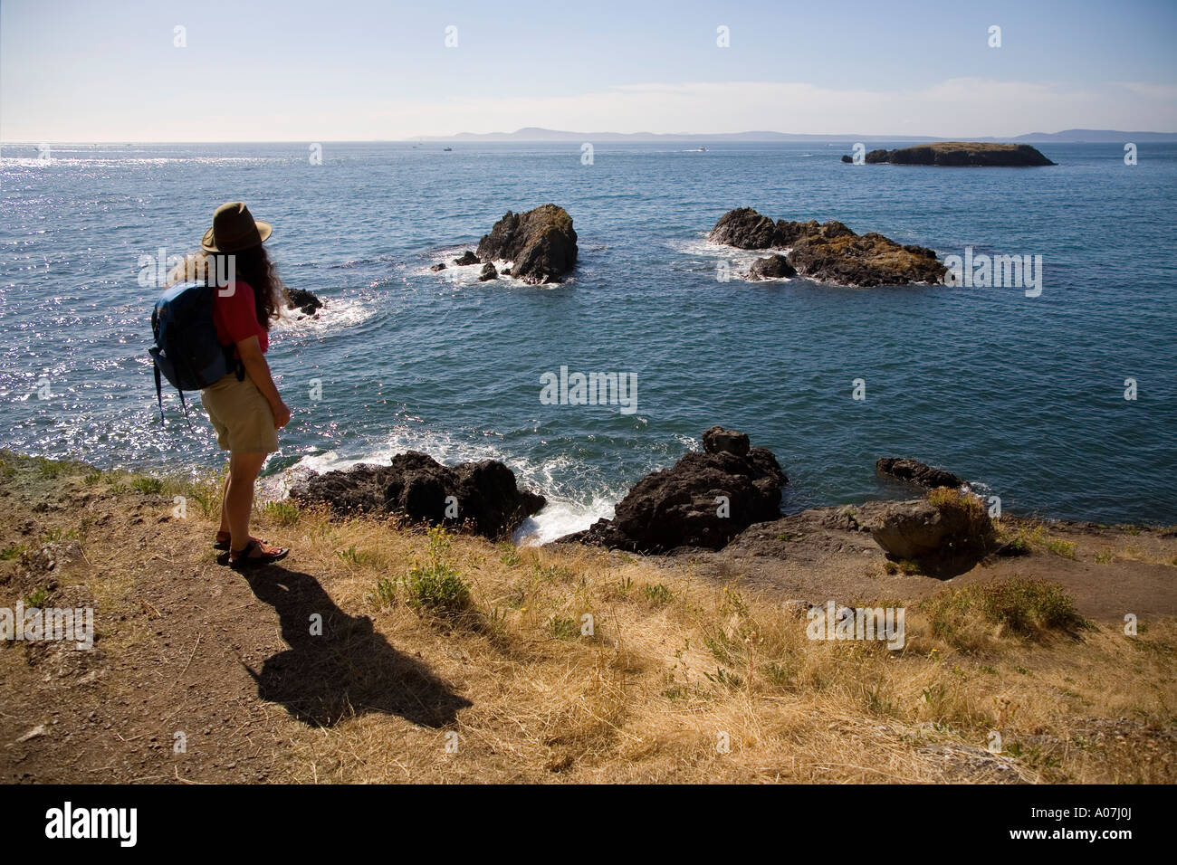 Woman on cliffs looking over Puget Sound Deception Pass state park ...
