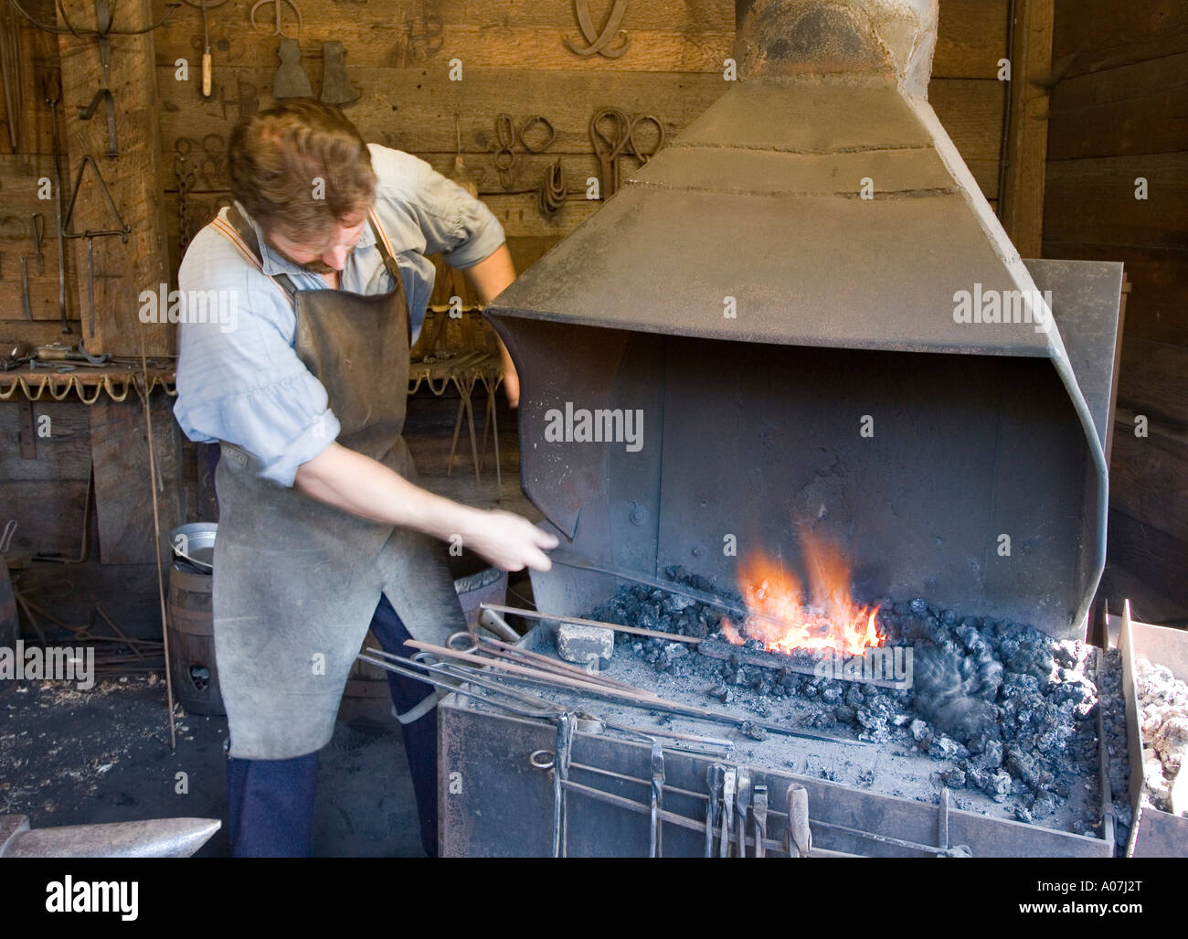 Blacksmith heating metal in traditional hand operated forge Fort ...