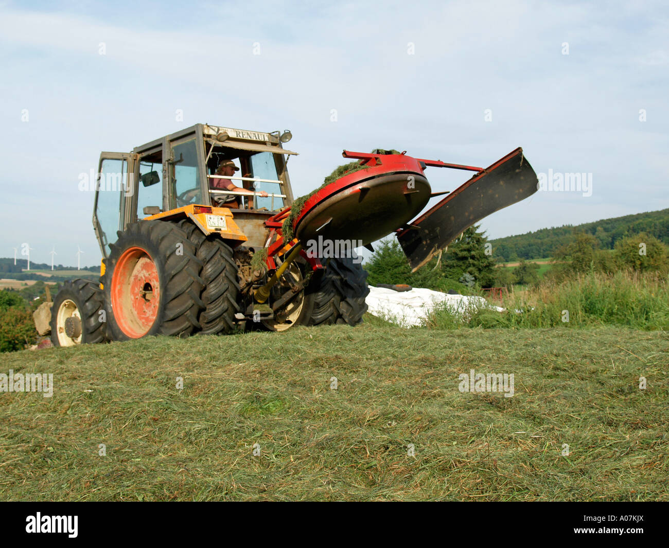 producing silage compressing the gras hay with a tractor in a field ...