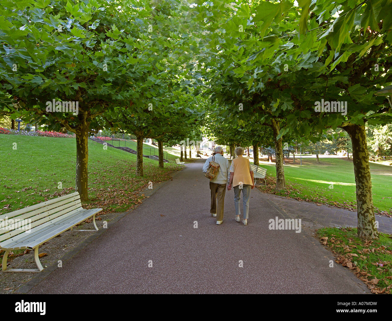 old married couple OAP old age pensioners going for a walk in a park ...