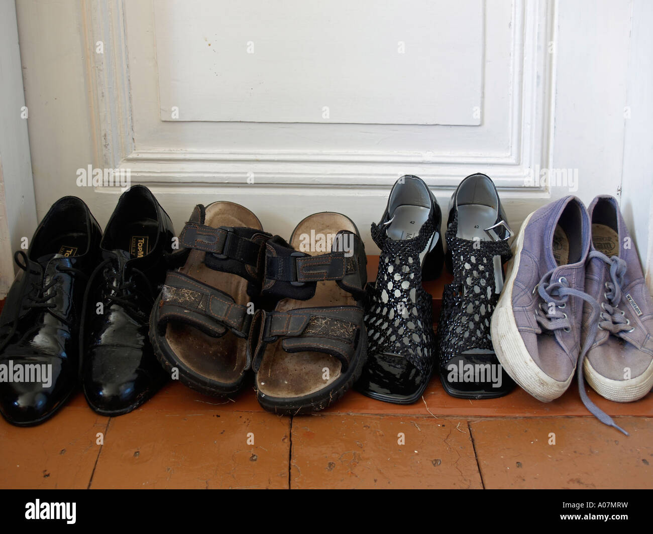 four diffrent pairs of shoes in front of a door Stock Photo - Alamy