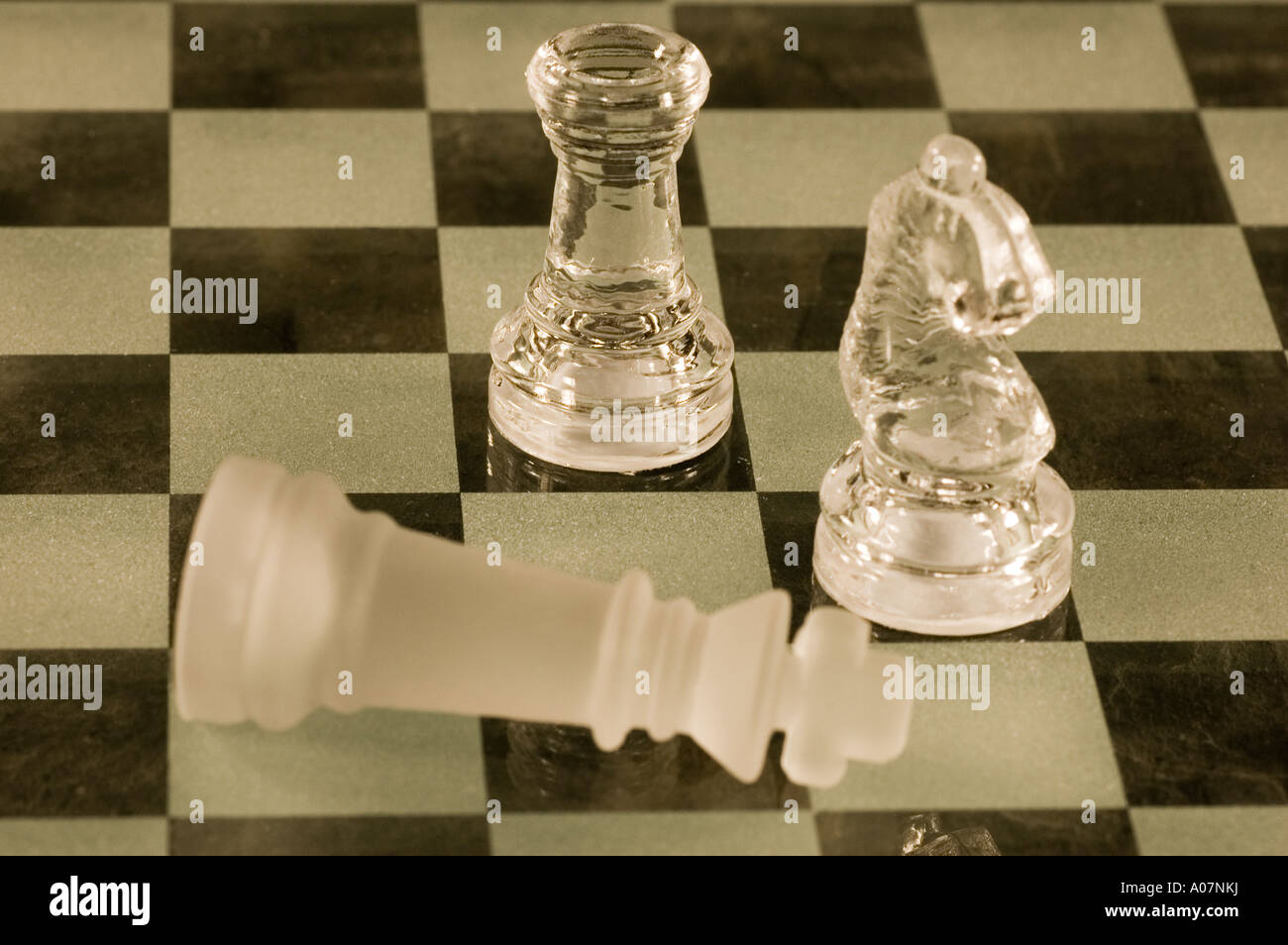 Glass Chess pieces on chessboard in checkmate Stock Photo - Alamy