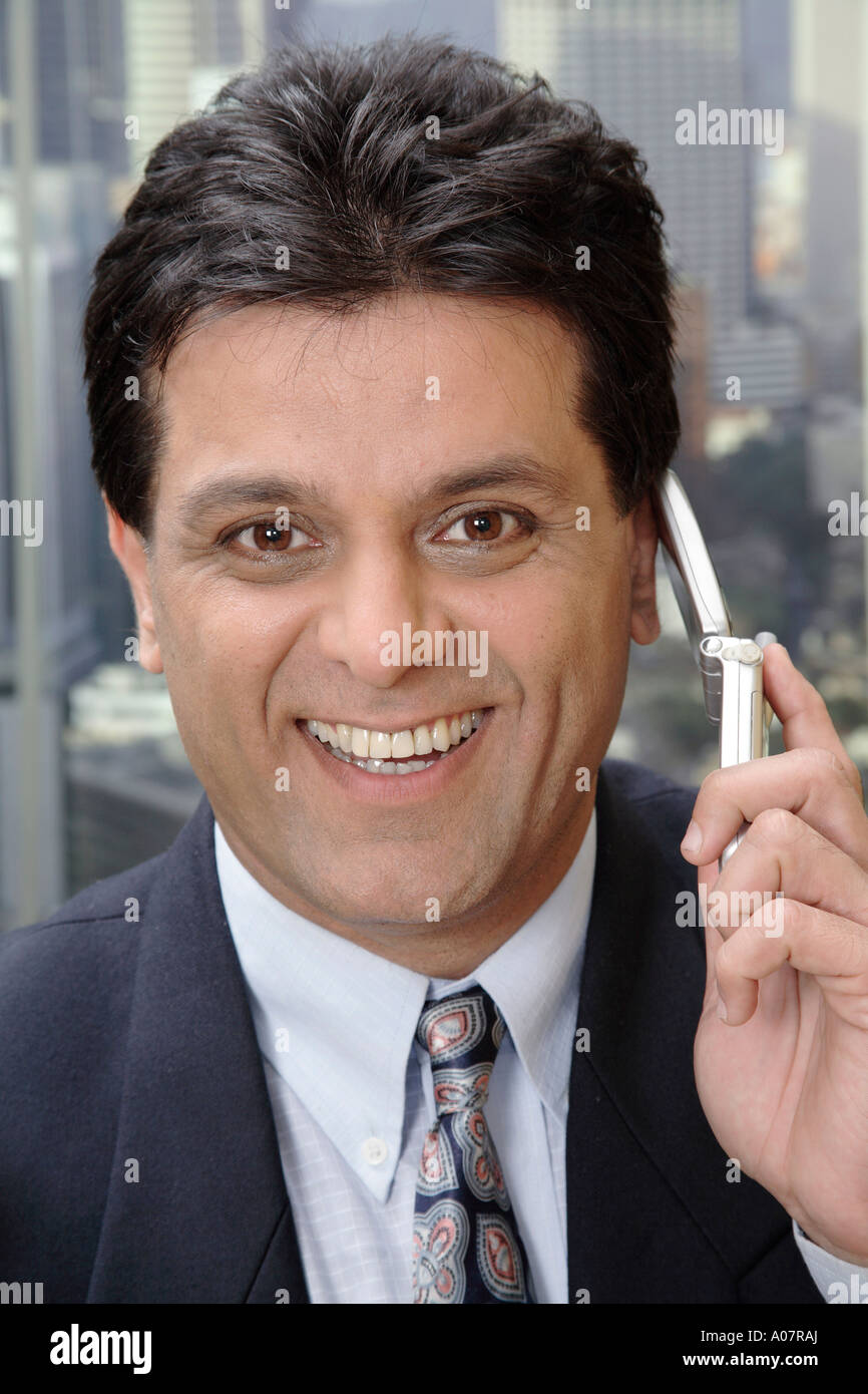 CEO smiling portrait talking on cellphone in his cabin in business suit ...