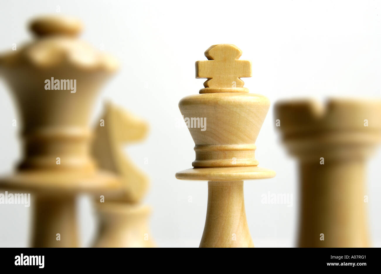 Chess pieces crafted from wood are arranged on a surface. The king ...