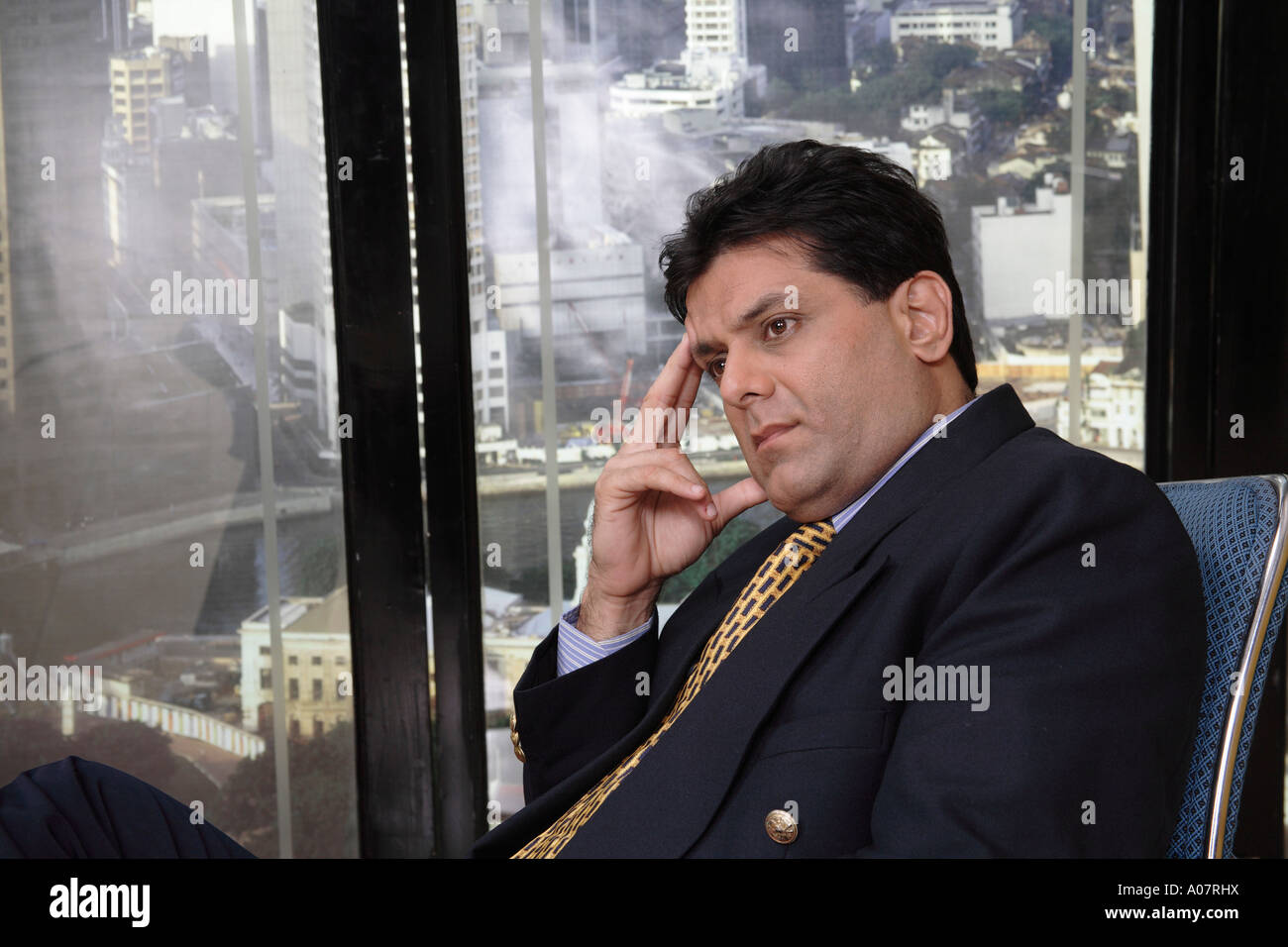 CEO thinking sitting in his cabin in business suit with city background ...