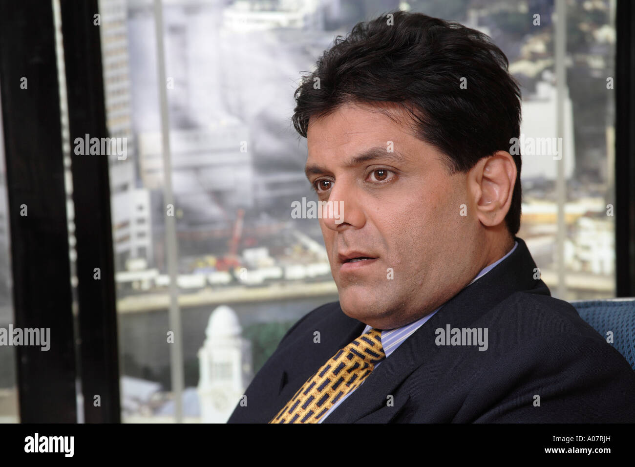 CEO thinking sitting in his cabin in business suit with city background ...