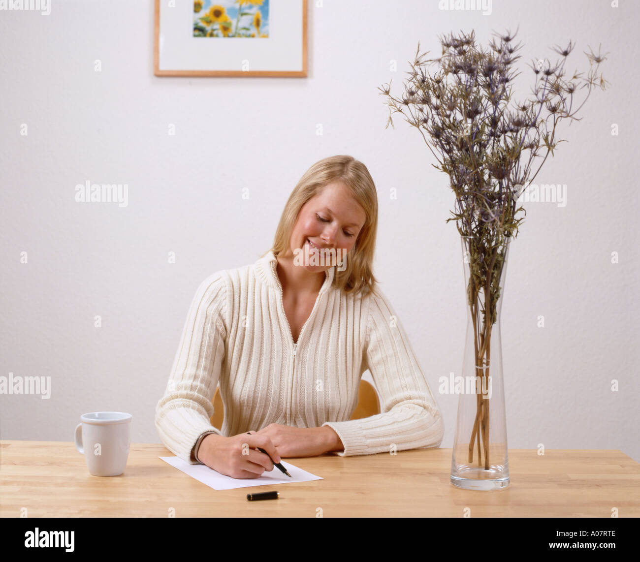 Woman seated at table writing letter Stock Photo - Alamy