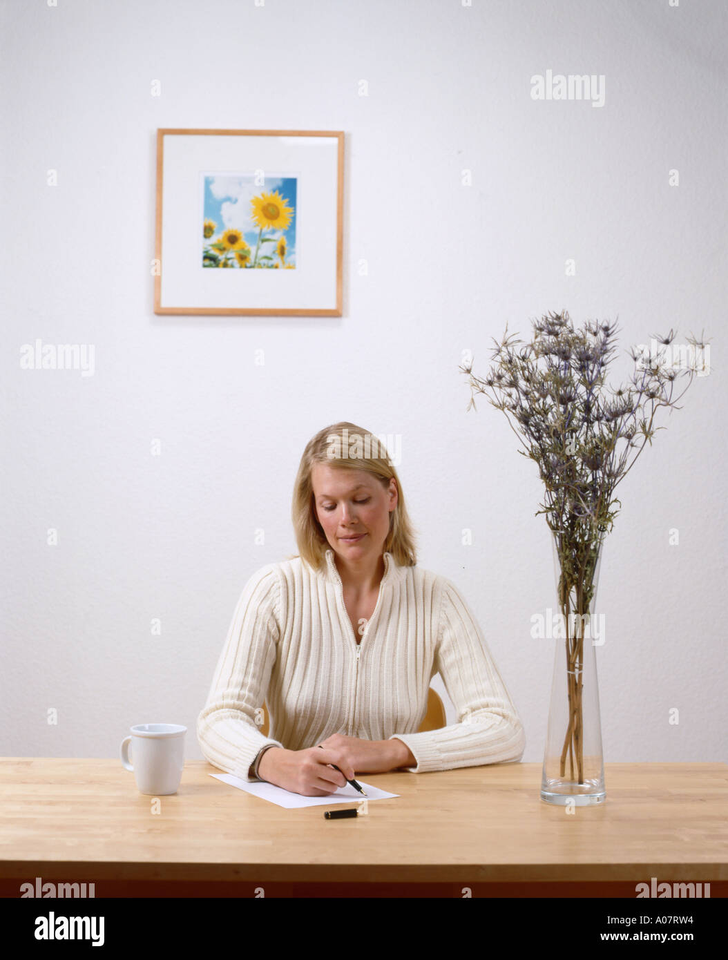 Woman seated at table writing letter Stock Photo - Alamy