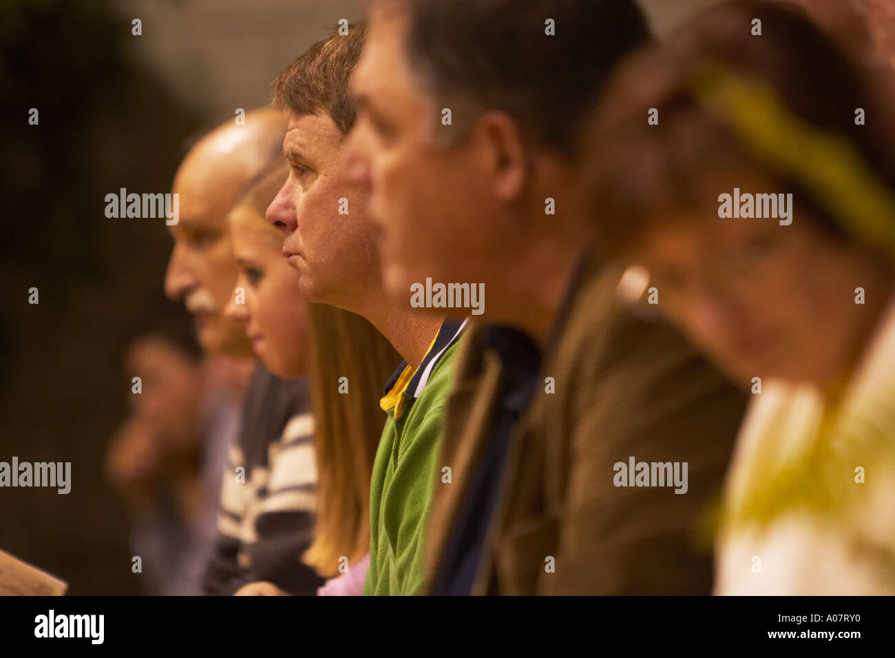A crowd of people looking somber at a memorial service after a death ...