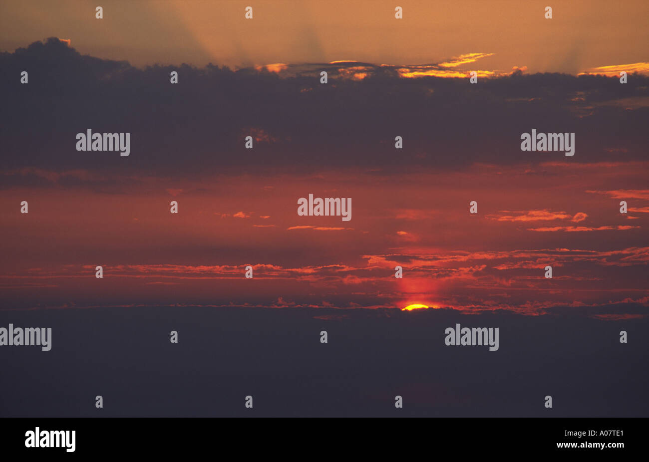 Sun setting into the clouds Stock Photo - Alamy