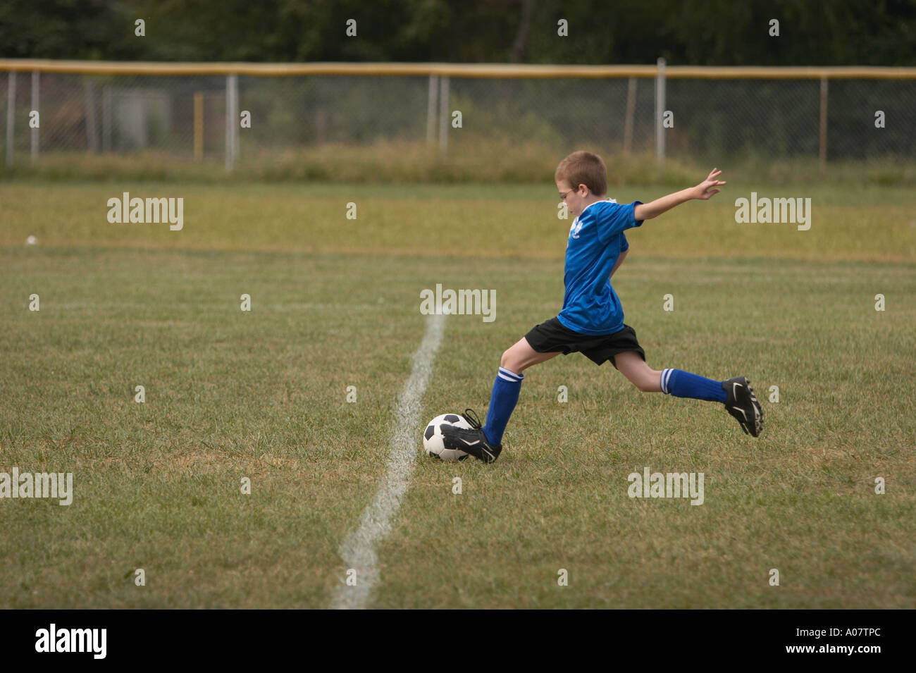 A boy playing soccer (football) in a youth league in the United States ...