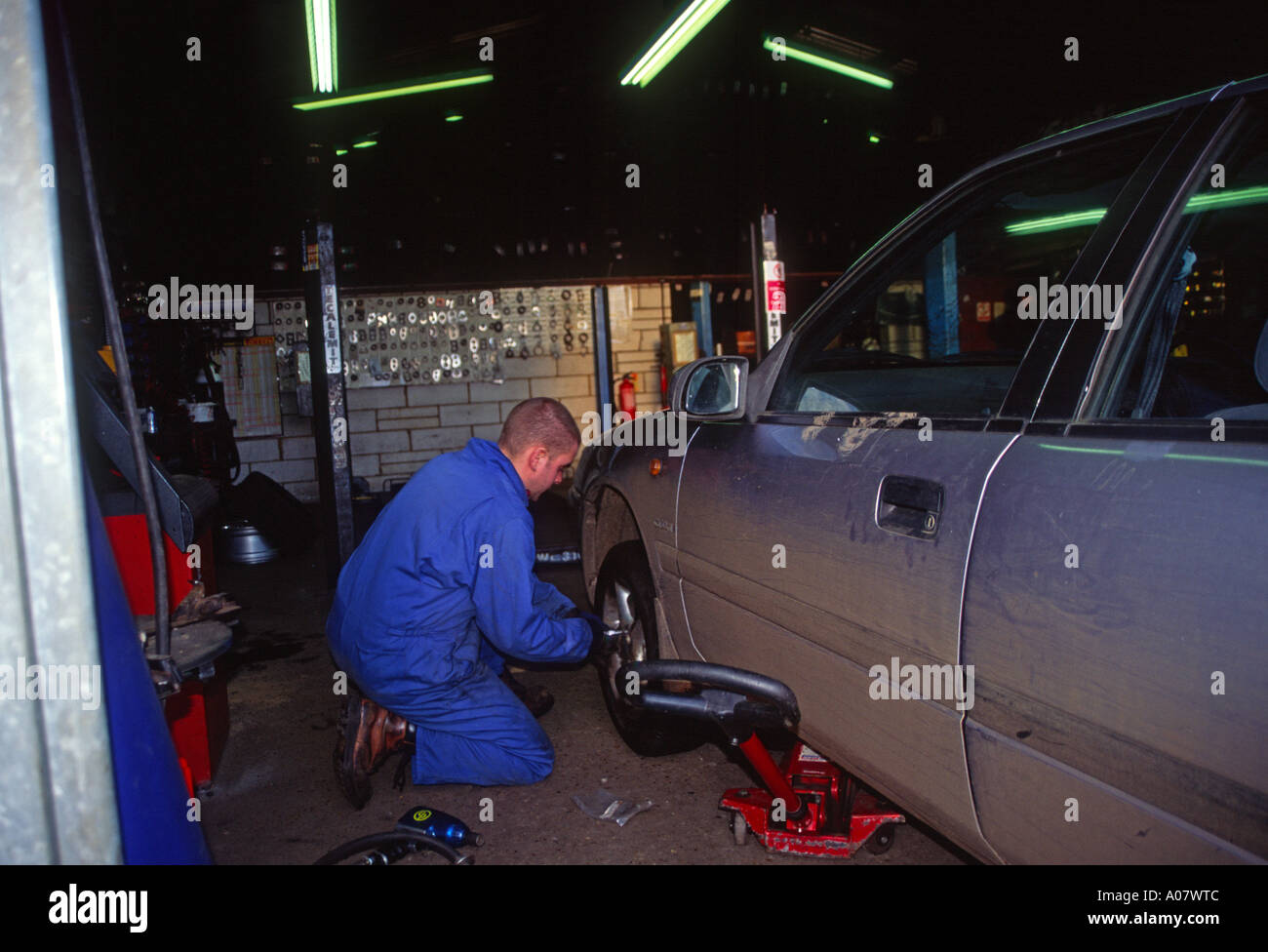 Mechanic changing wheel Stock Photo - Alamy
