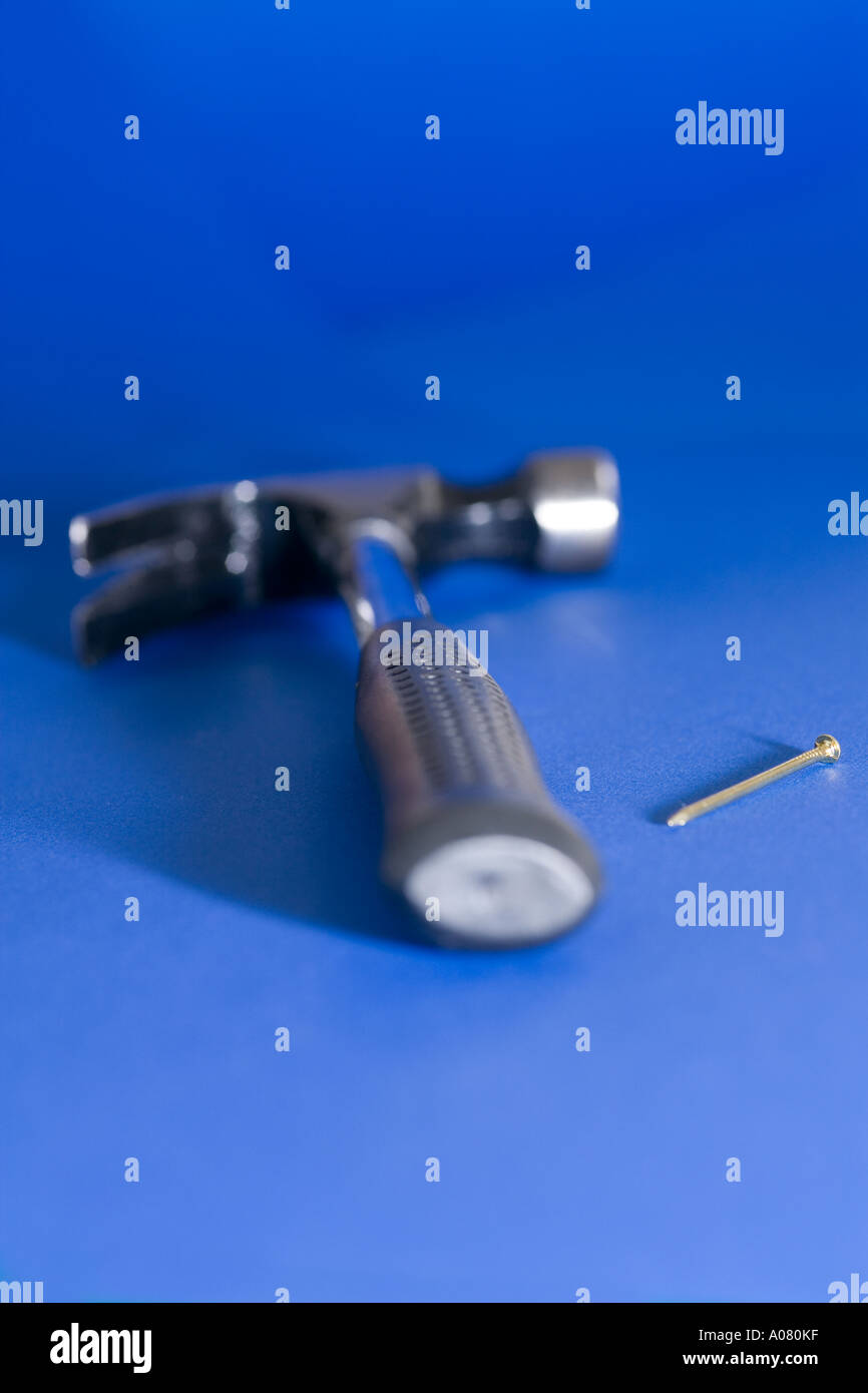 Hammer and stud on blue background Stock Photo - Alamy