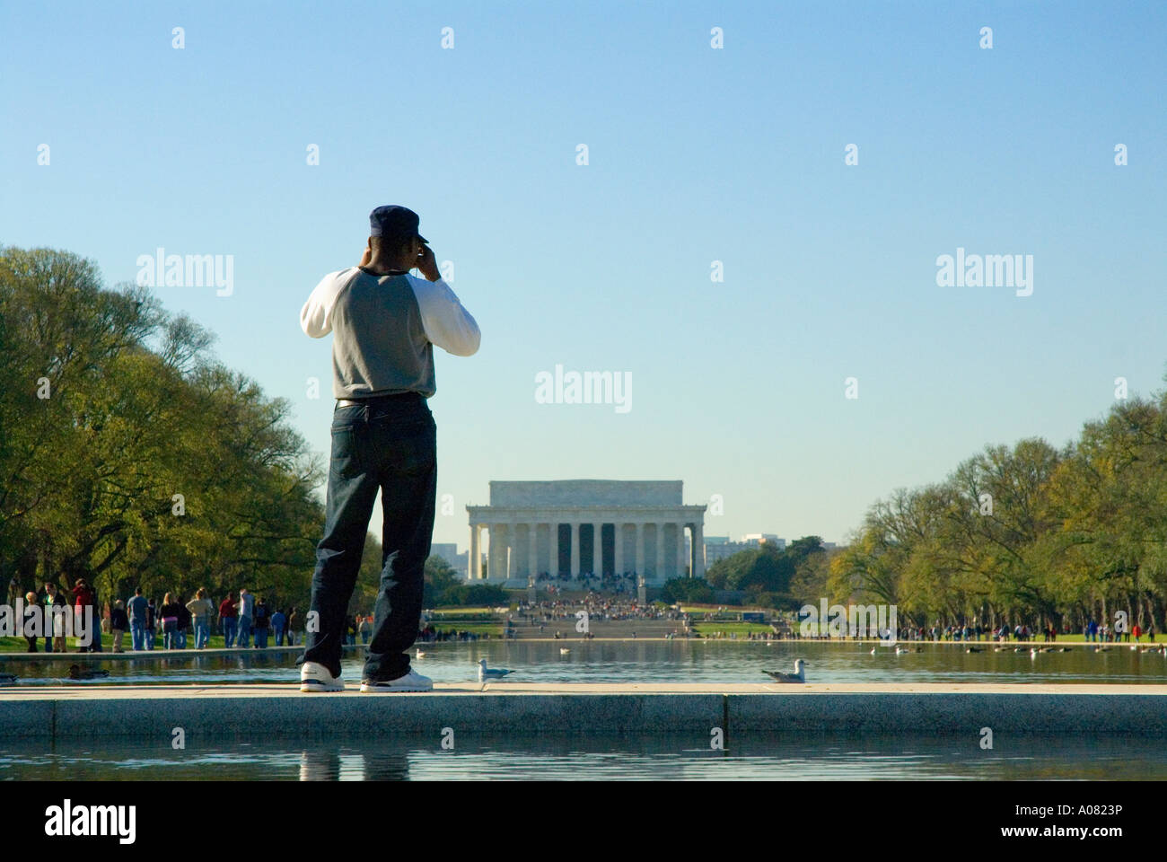 Tourists taking photos at the Reflecting Pool with Lincoln Memorial in ...