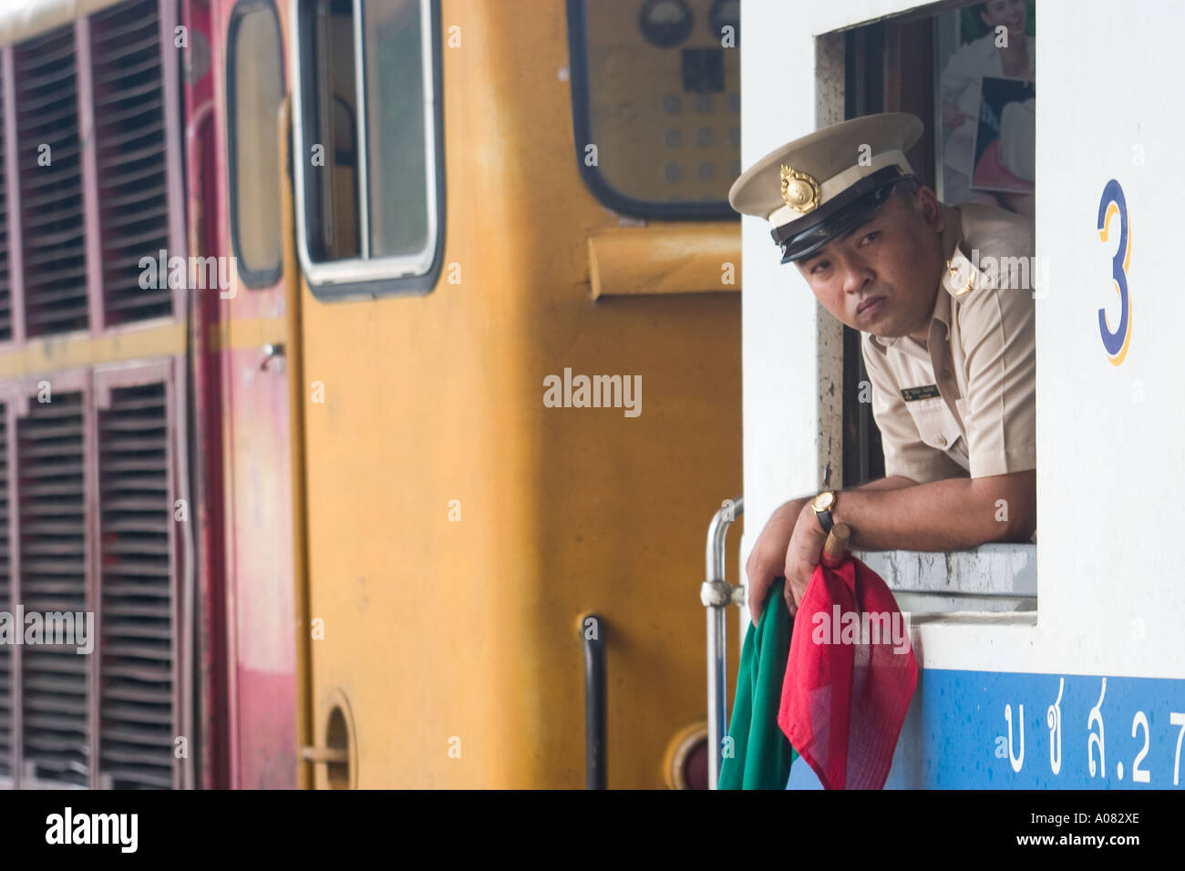 Thailand Train conductor leans out window at Thonburi station with ...