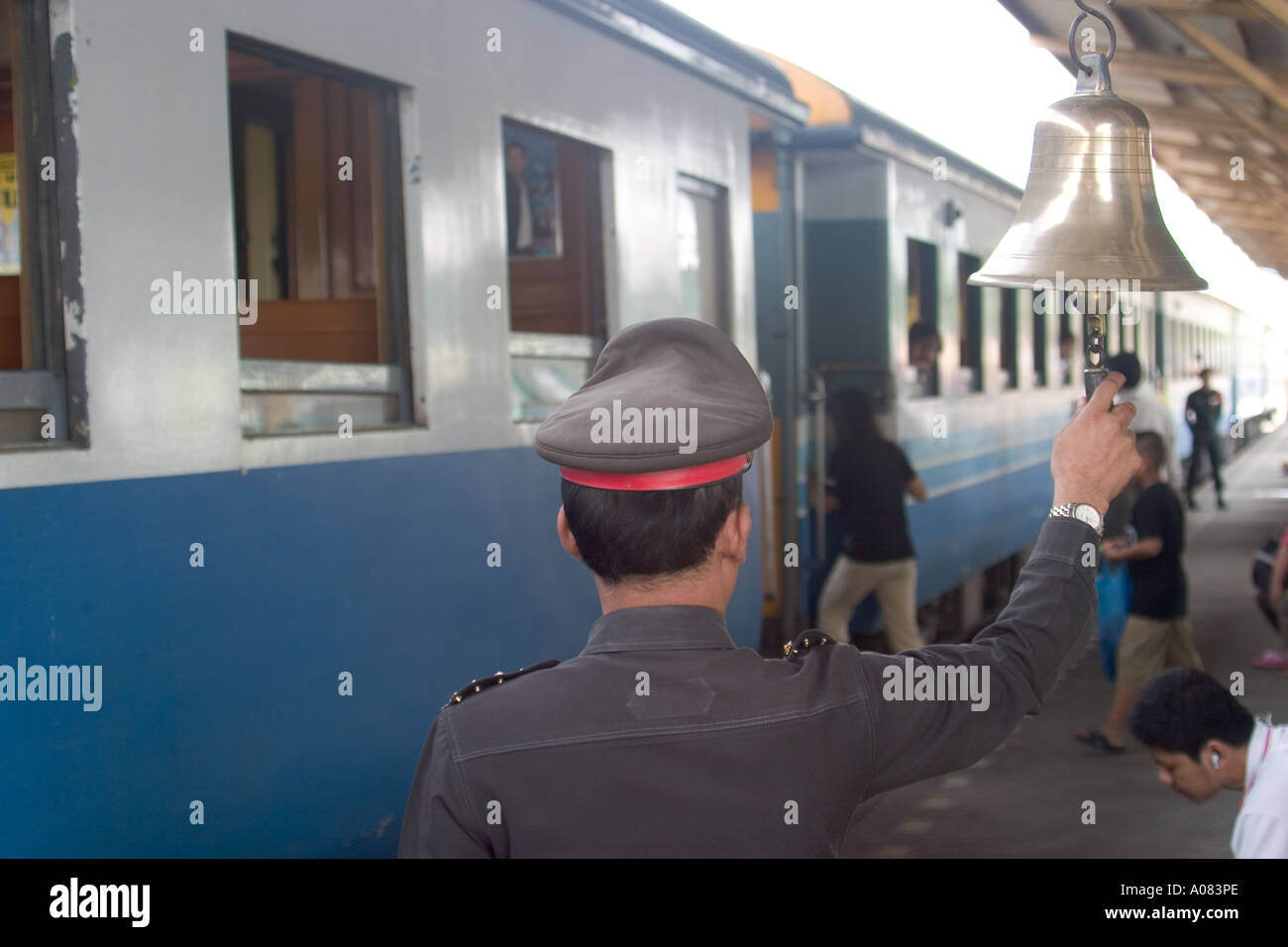 Conductor ring bell to signal departure of train from Thonburi Station ...