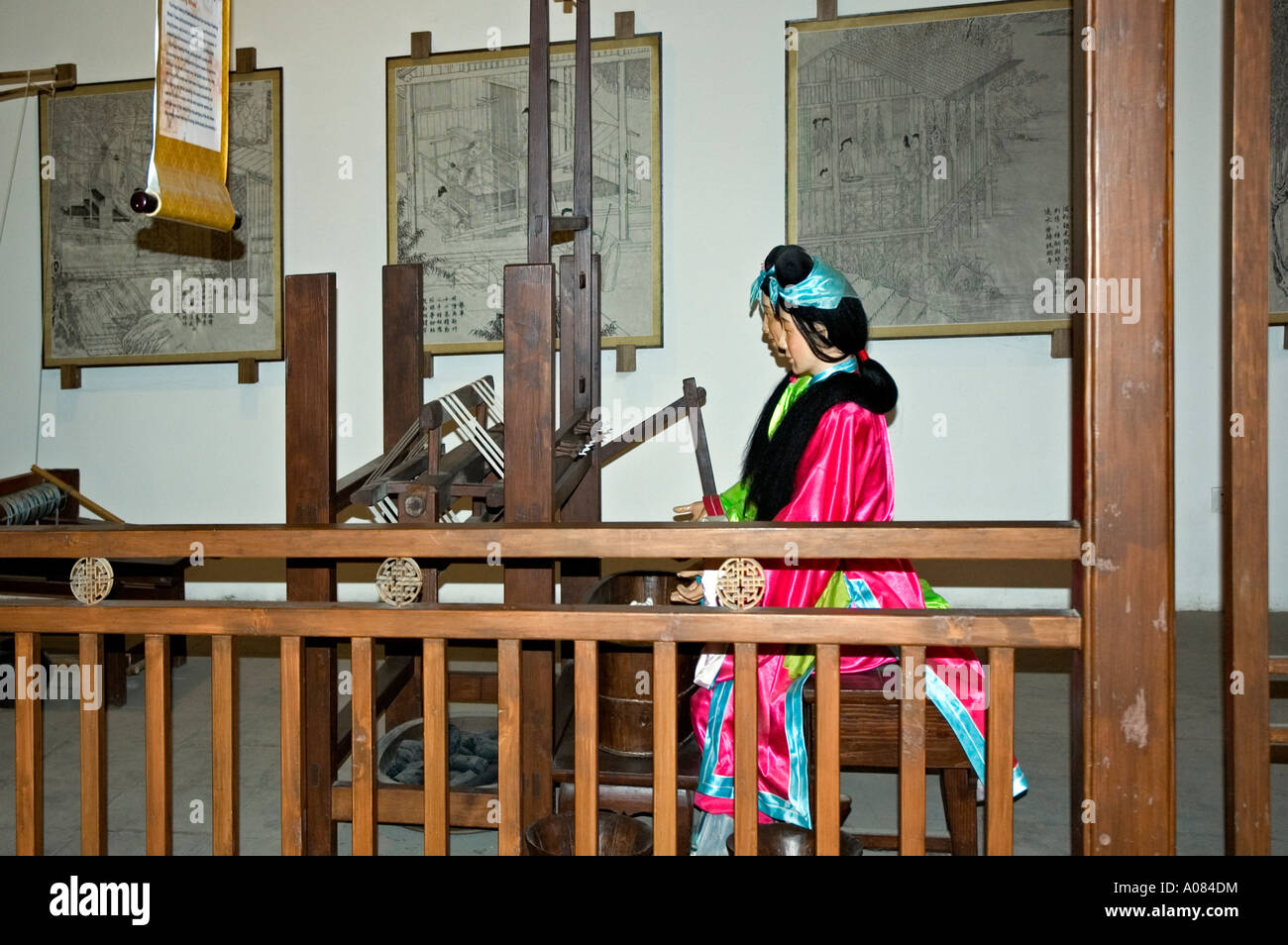 Two historical models of female Chinese workers weaving silk at a loom ...