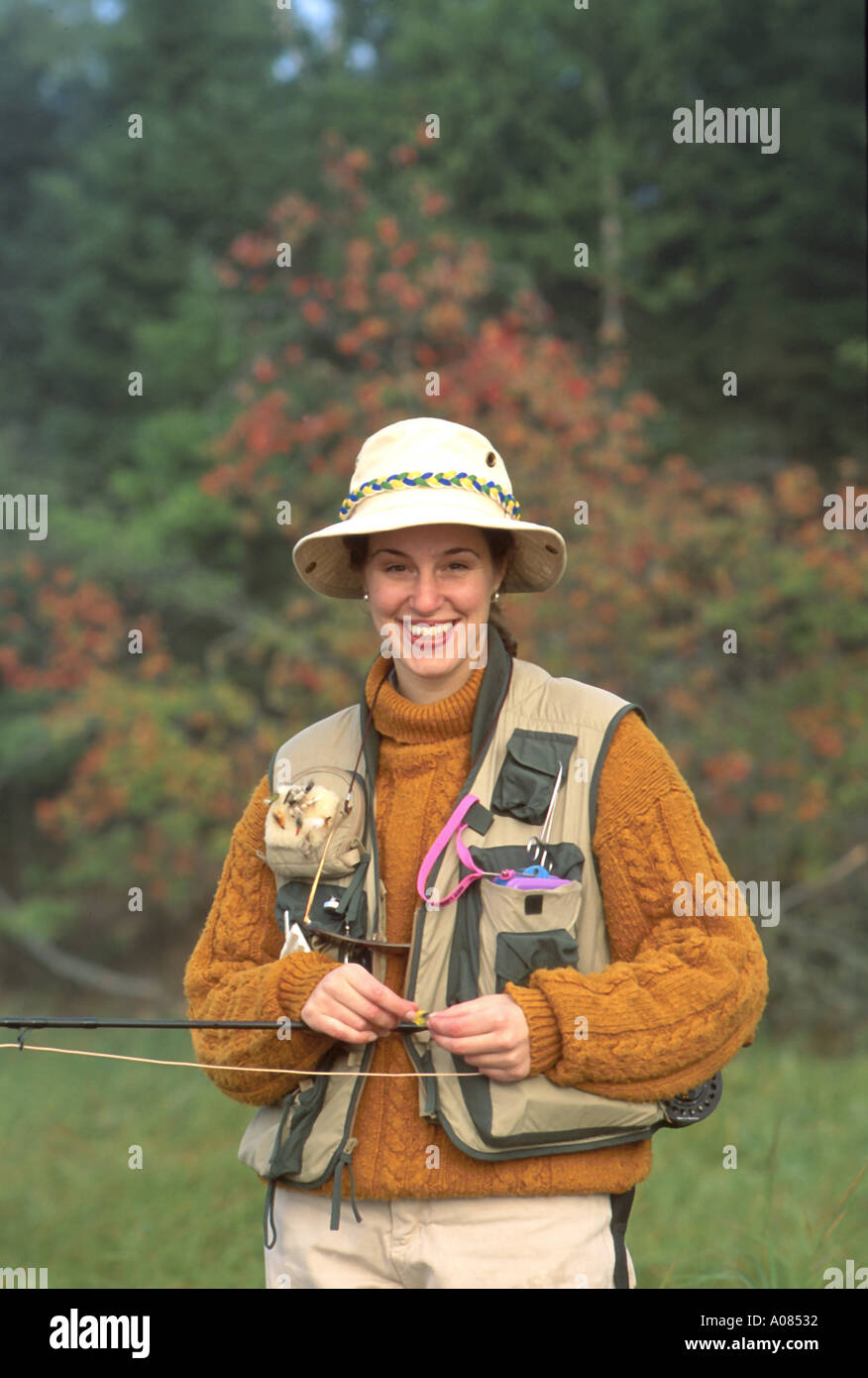 Young happy woman fly fishing on the Miramichi River in New Brunswick ...