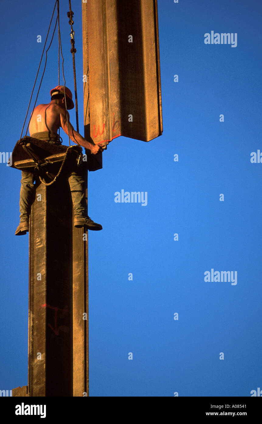 Construction worker lining up steel post for bridge building on Trans ...