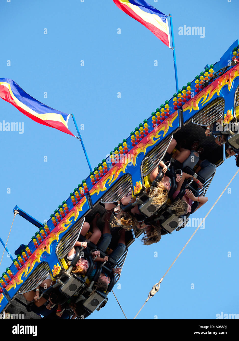 Roller coaster riders hang on as they are sent upside down through the ...