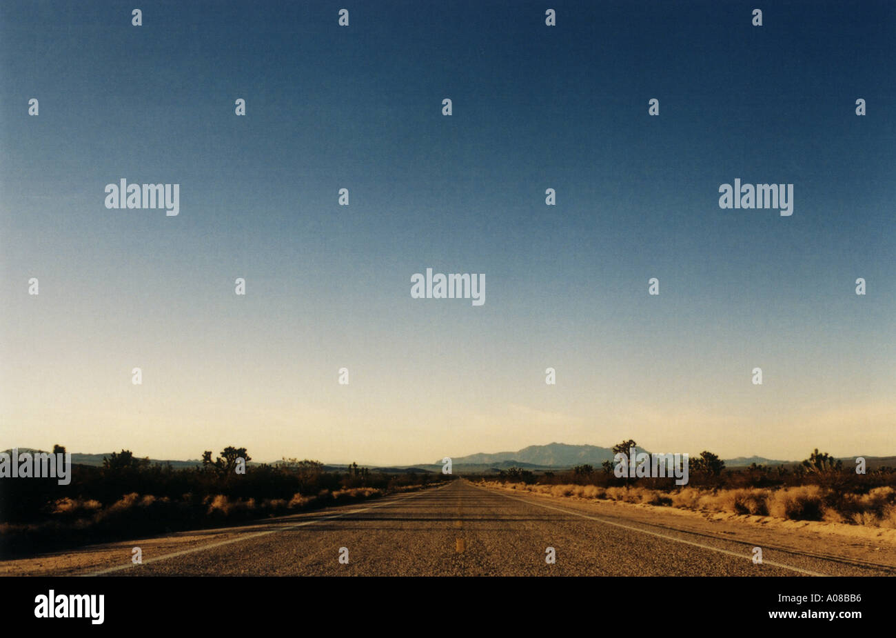 Empty highway in desert with blue sky above Mojave Desert California ...