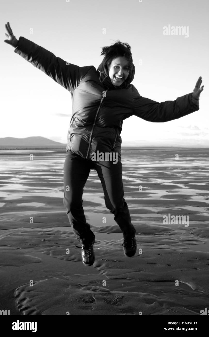 jumping beach female skinburness Stock Photo - Alamy