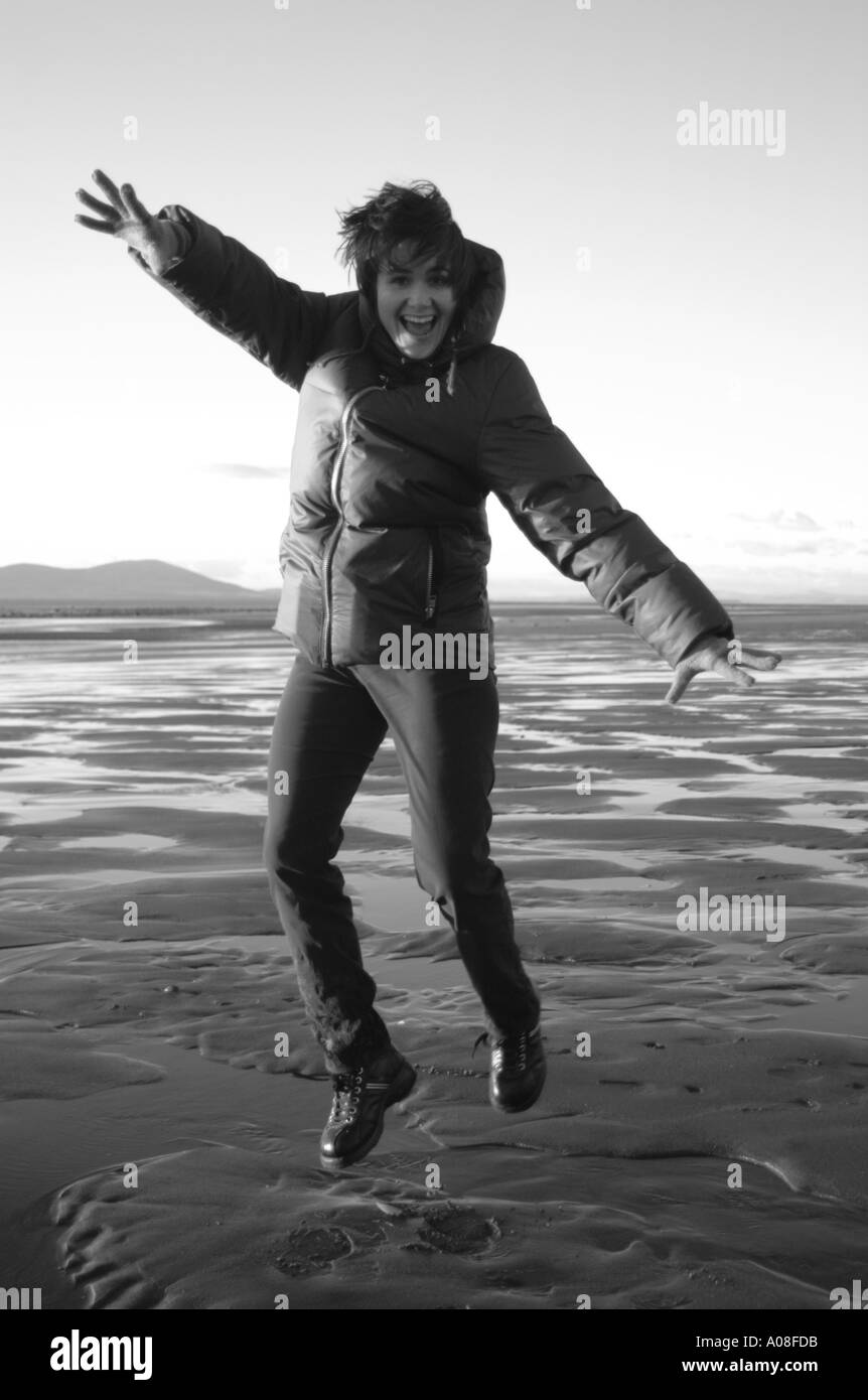 jumping beach female skinburness Stock Photo - Alamy