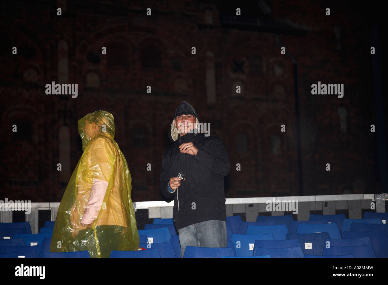 People in the rain at an outdoor cultural event at night Stock Photo ...