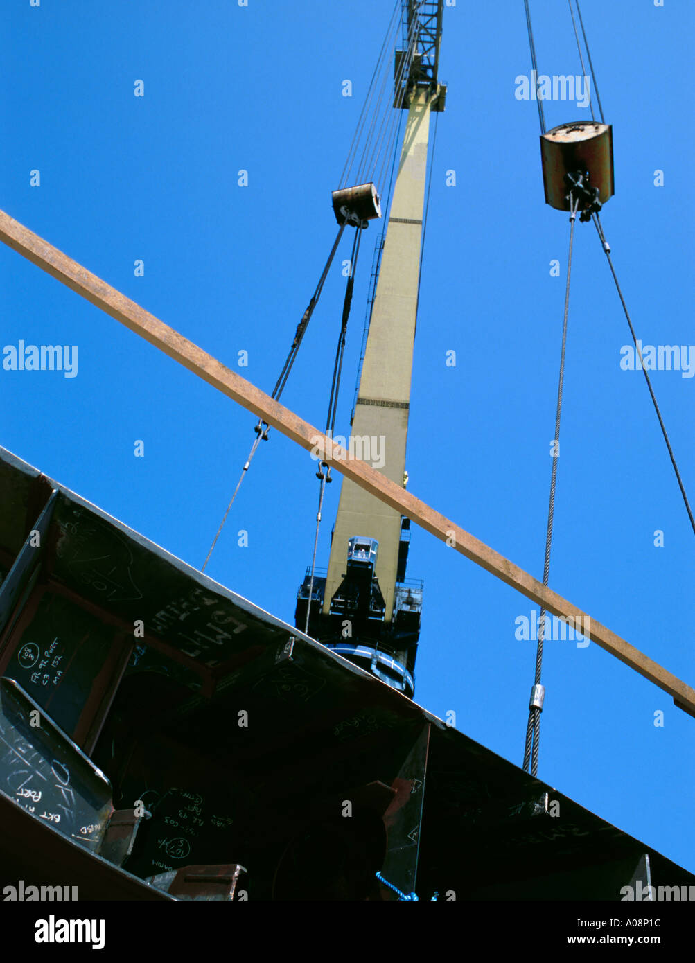 Large crane positioning a section of the keel of a ship on a shipyard ...