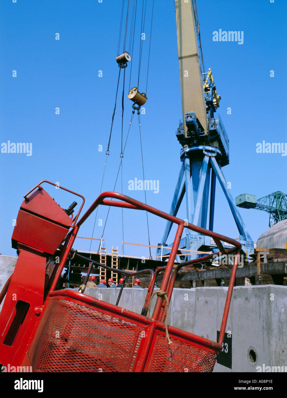 Large crane positioning a section of the keel of a ship on a shipyard ...