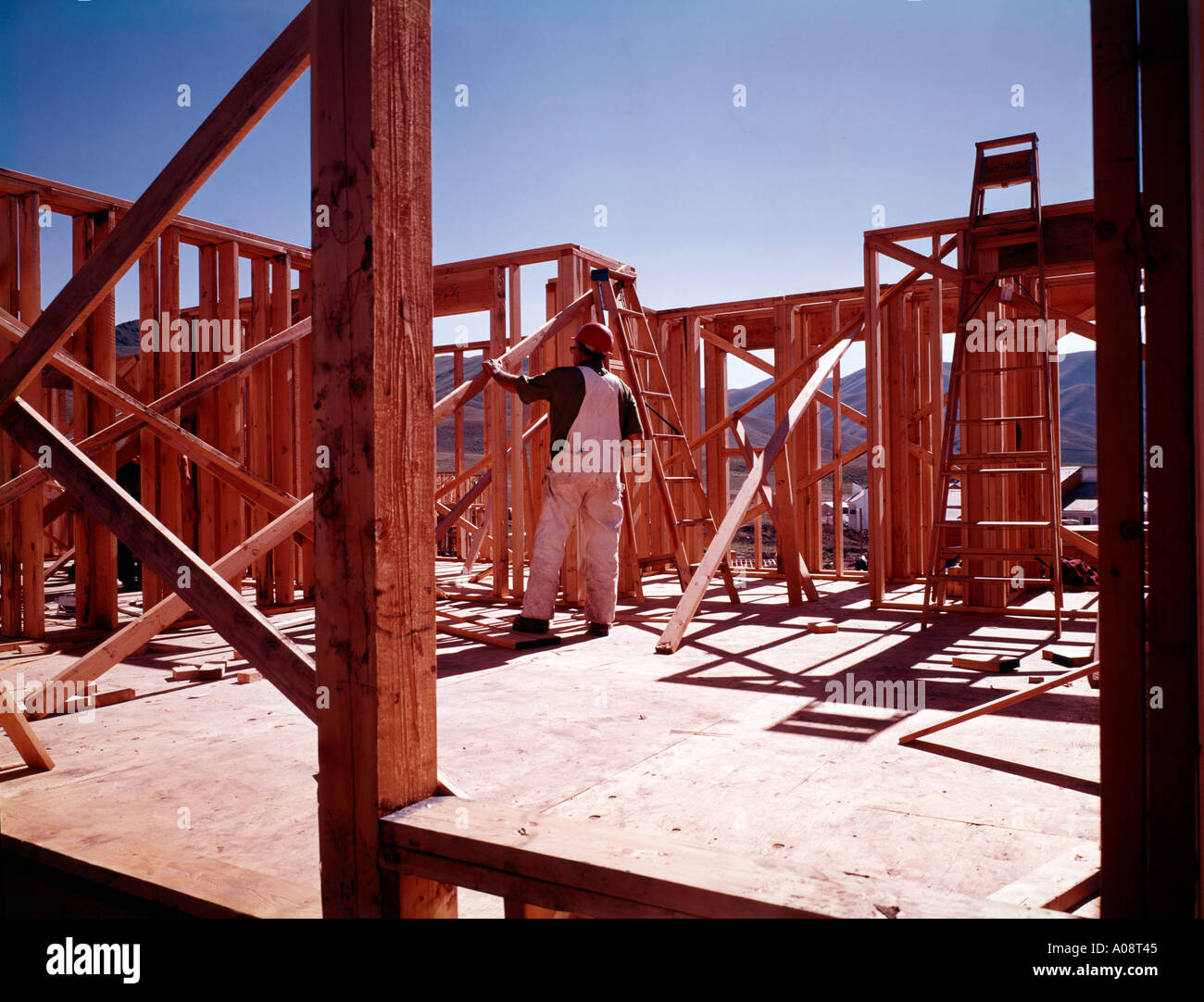 Carpenters framing a building with wood 2X4 and other timbers creating ...