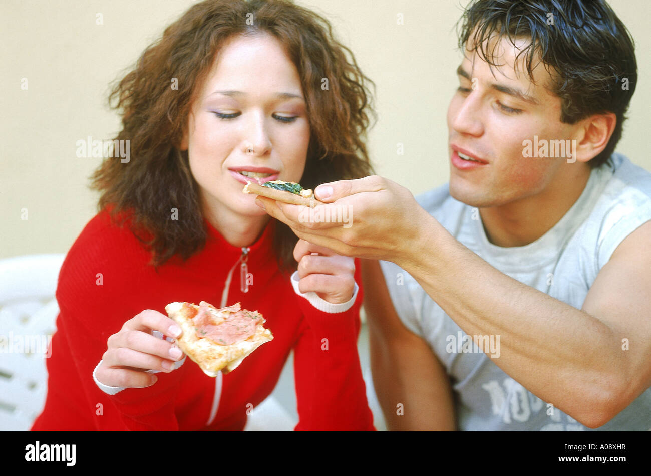 Loving couple biting pizza hi-res stock photography and images - Alamy