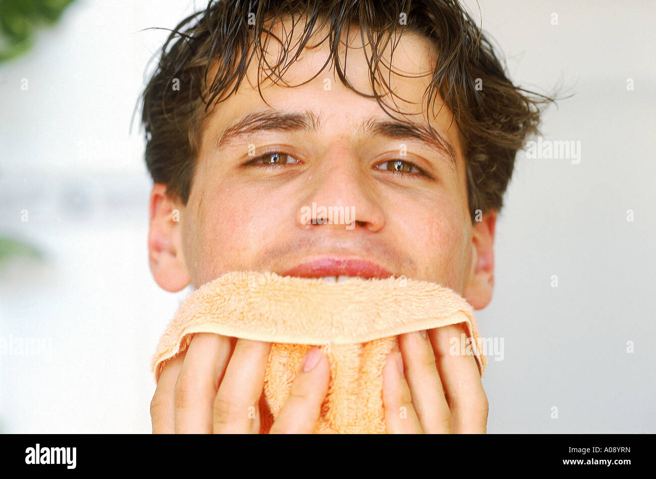 Young man wiping his face with a towel Stock Photo - Alamy