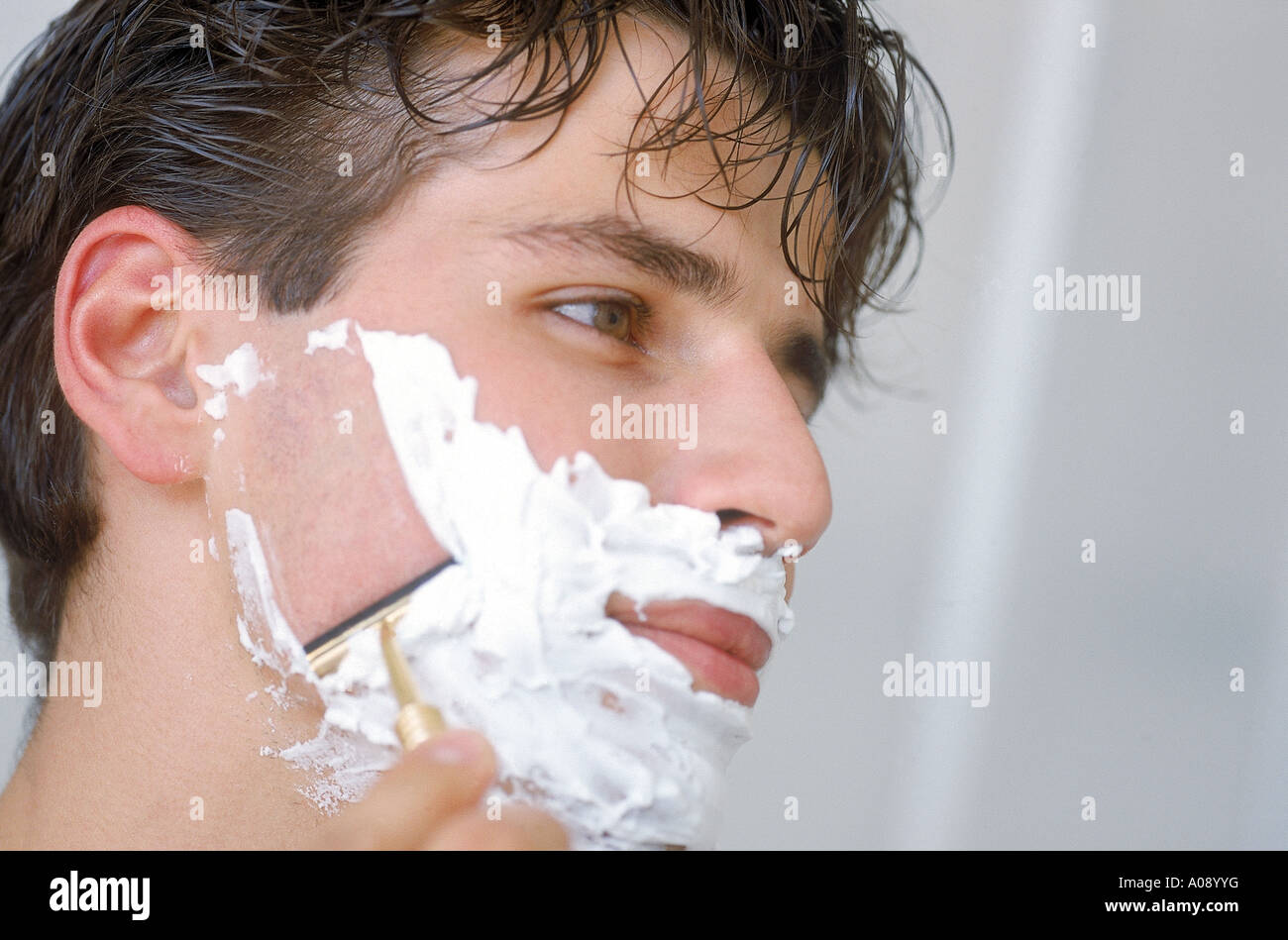 Young man shaving his face Stock Photo - Alamy