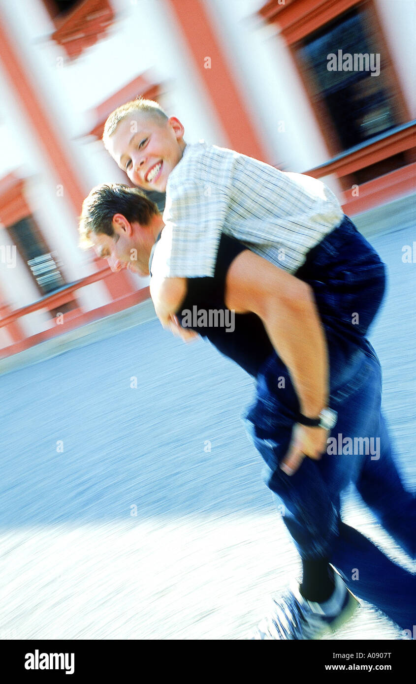 Blurred side profile of a man carrying a boy on his back Stock Photo ...