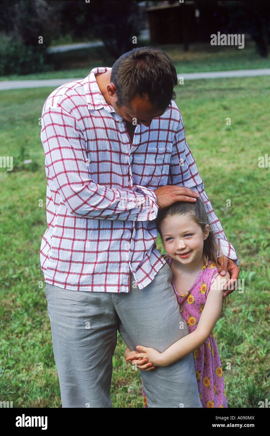 Young girl holding her fathers leg Stock Photo - Alamy