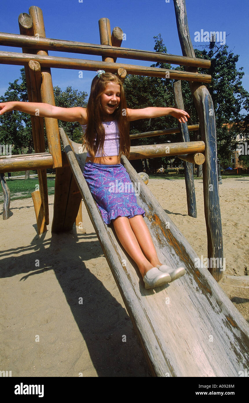 Girl sliding in a playground Stock Photo - Alamy