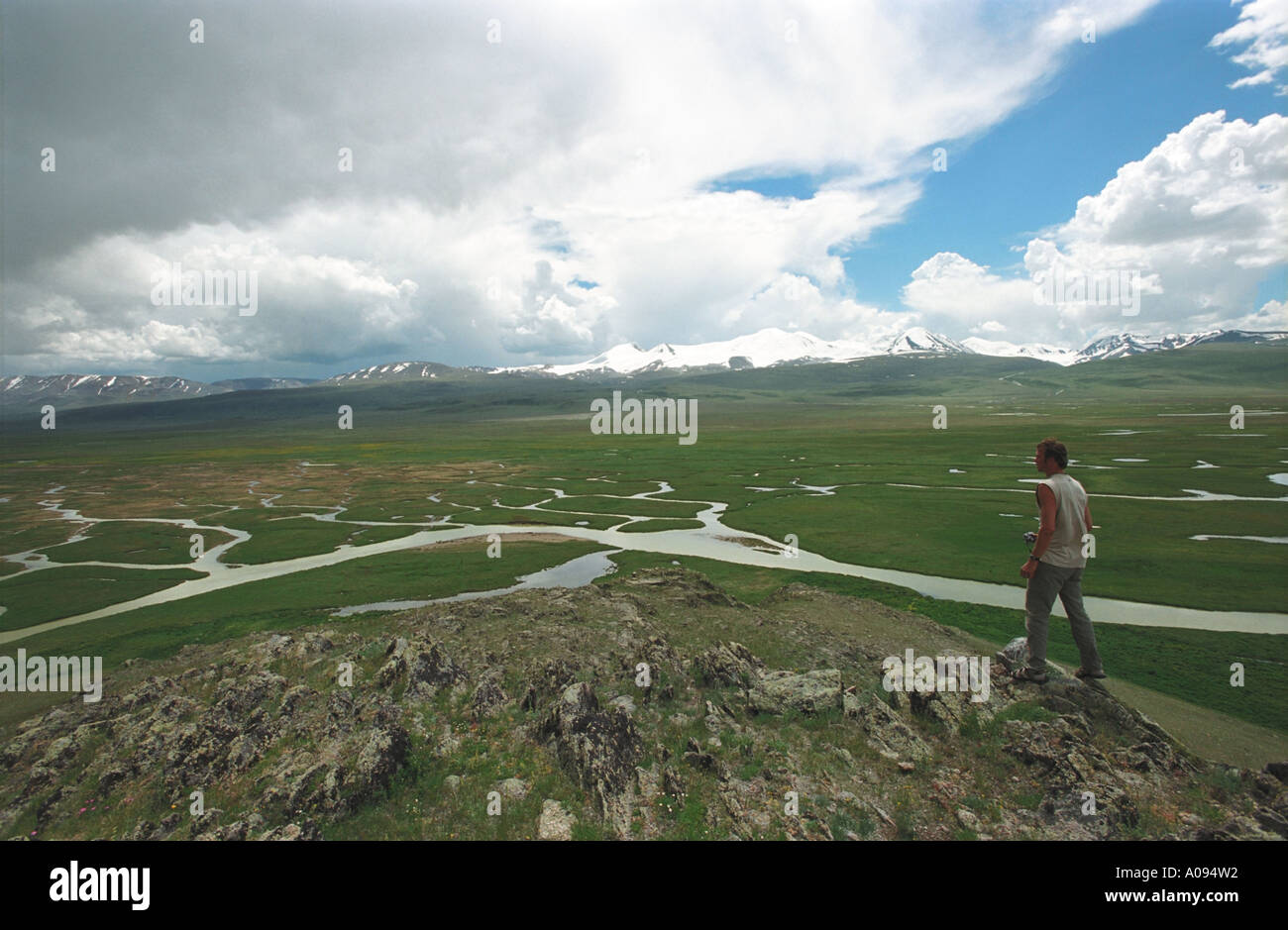 A man is looking at the Ukok Plateau and the Tabyn Bogdo Ola Range ...