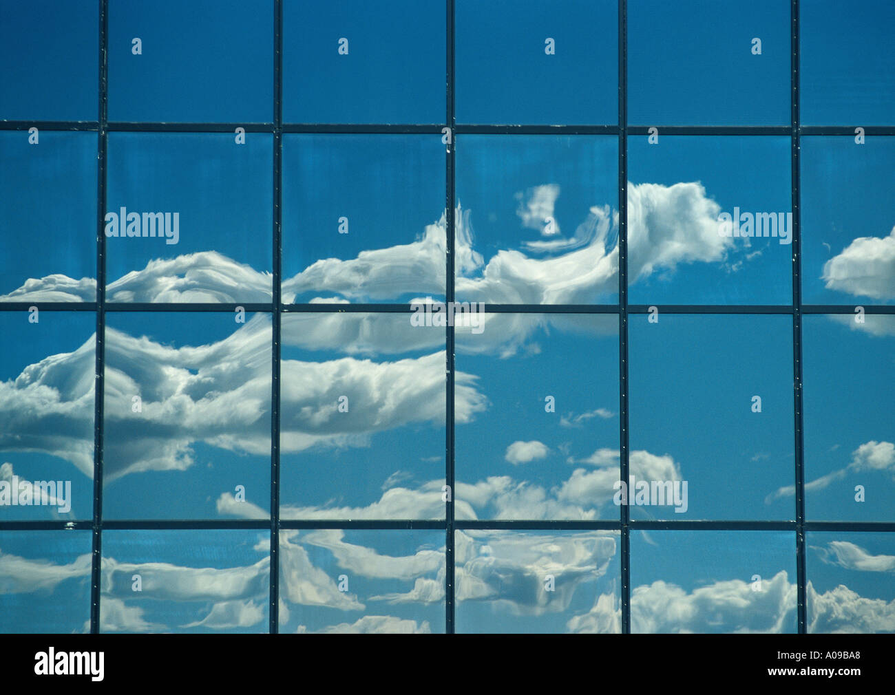 Puffy white clouds reflected in the glass panels of a skyscraper s ...