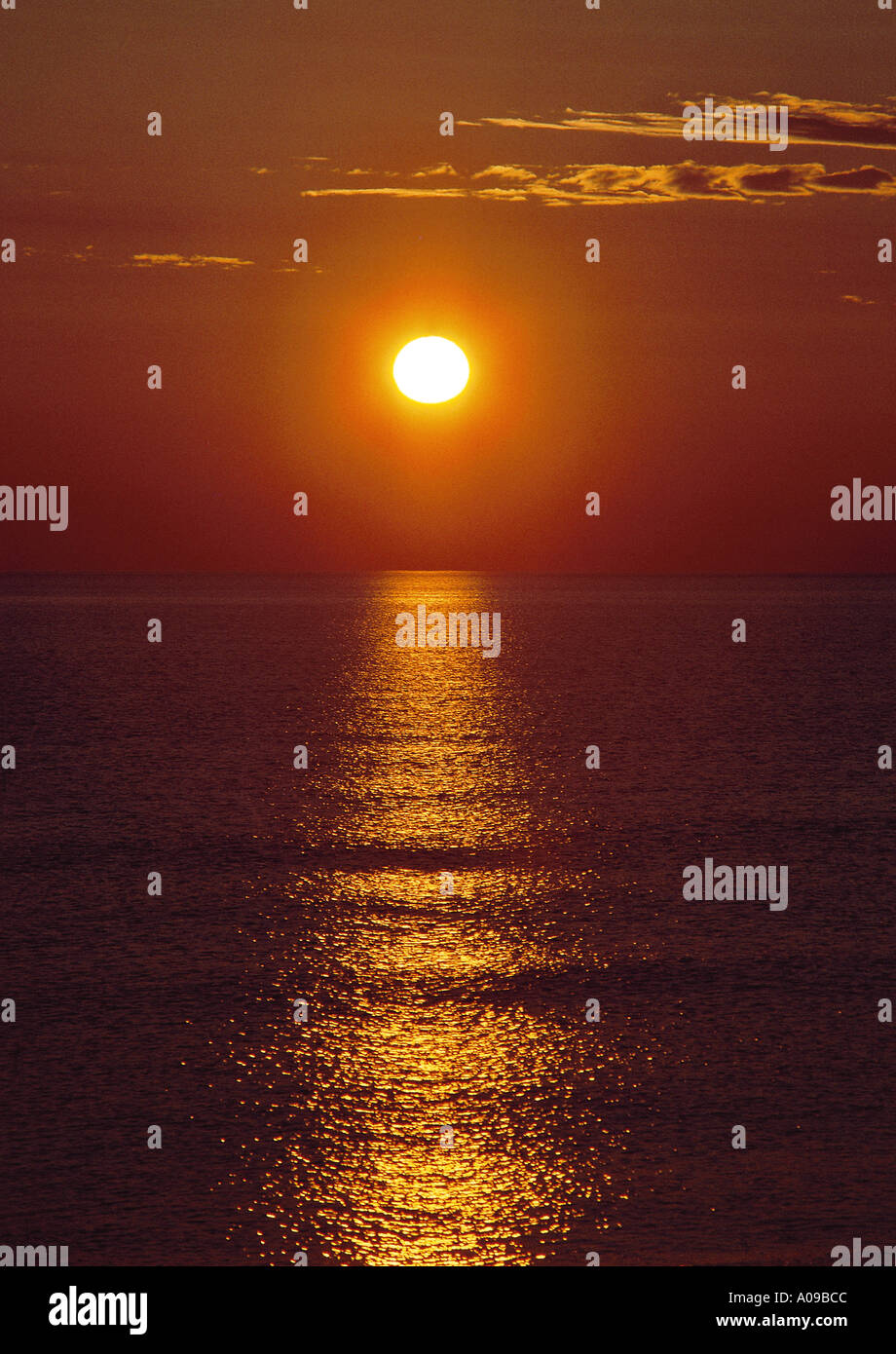 Sunset casting a reflection over a large body of water Stock Photo - Alamy