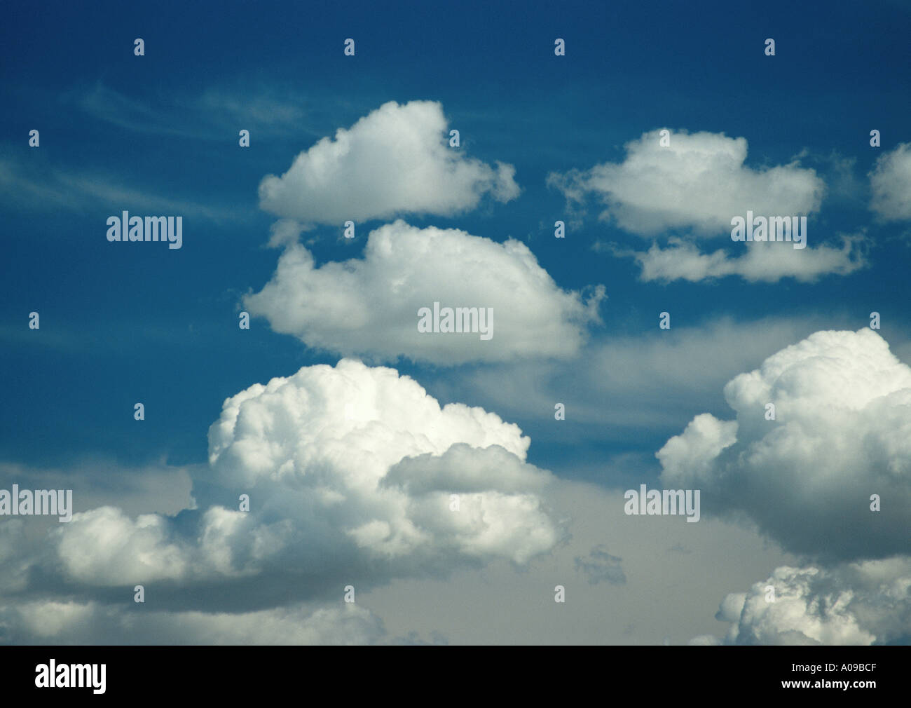 A bright blue daytime skyscape with pillowy white puffy clouds in the ...