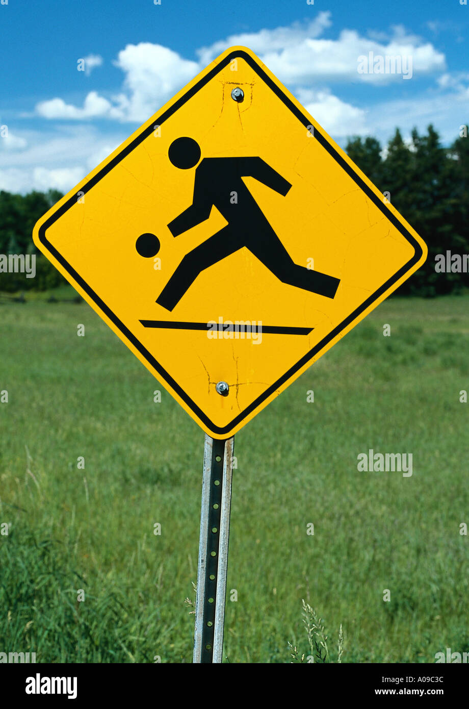 Playground zone sign with field and trees in background Stock Photo - Alamy