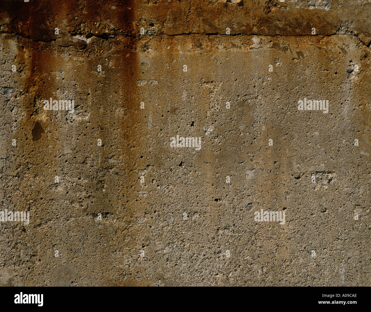 A close up of an aged and weathered cement or concrete wall with rust ...