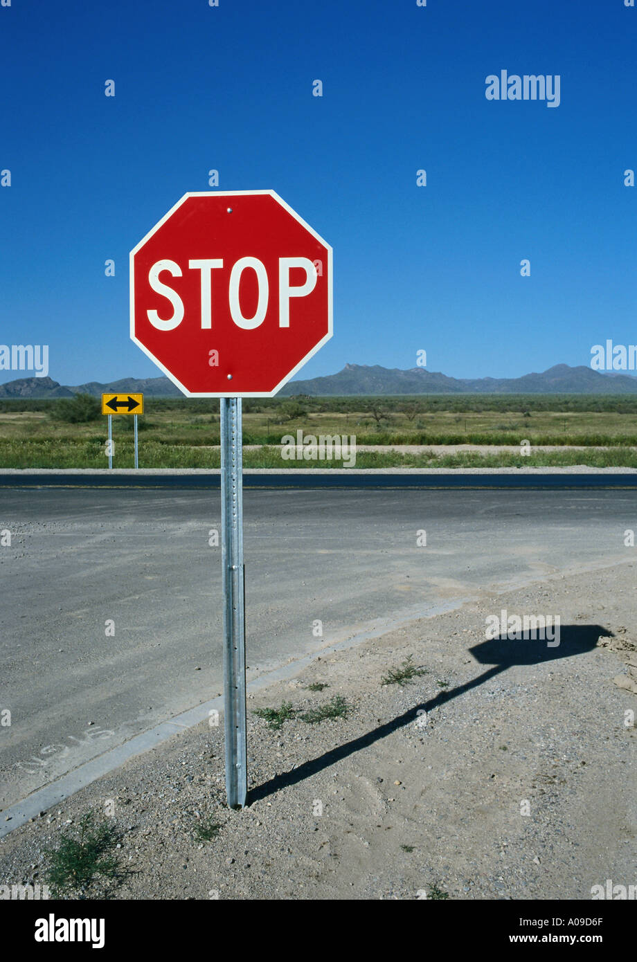 STOP sign at T intersection of two paved roads Stock Photo - Alamy