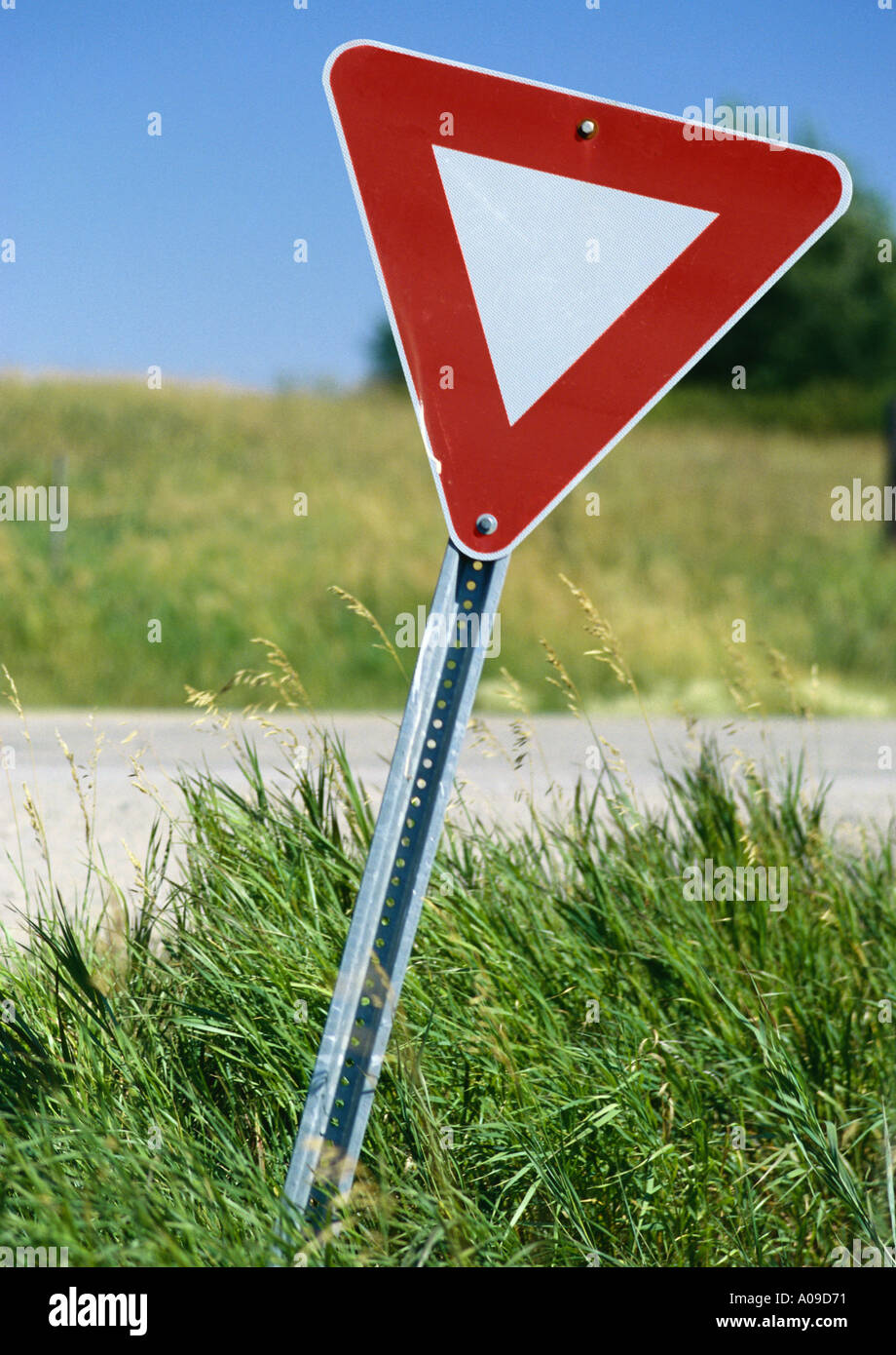 Tilted triangular yield sign in rural setting Stock Photo - Alamy