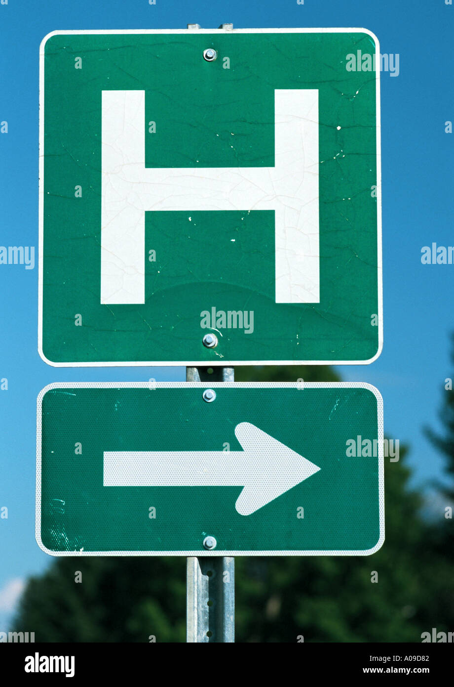 A green and white rectangular hospital turn right road sign on a metal ...