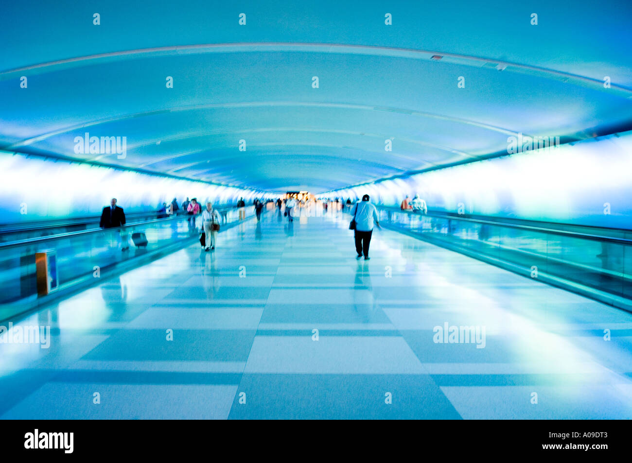 travelers move through the colorful subterrainean moving walkway area ...