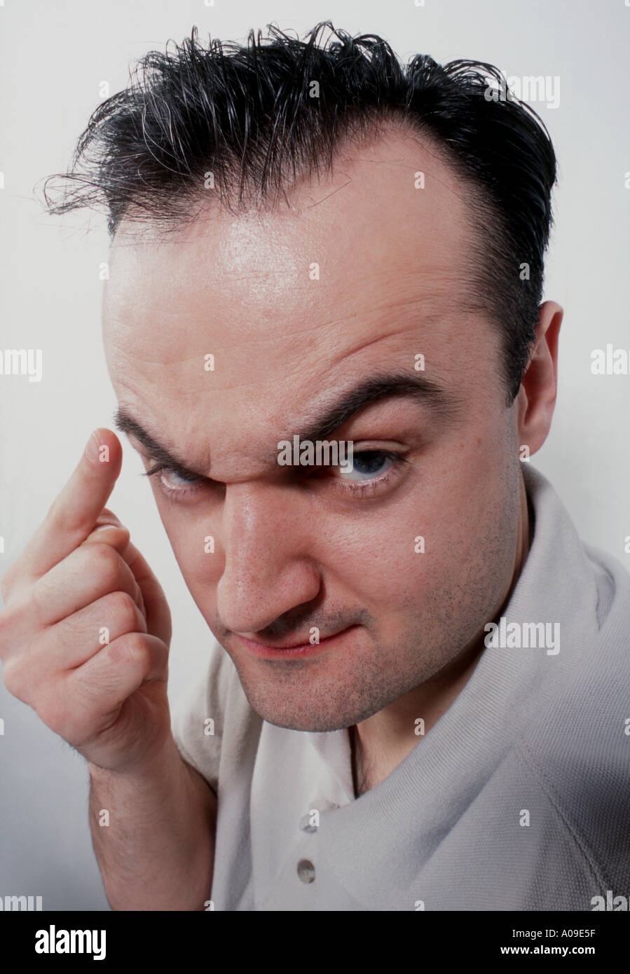 portrait of man pointing to head with finger Stock Photo - Alamy