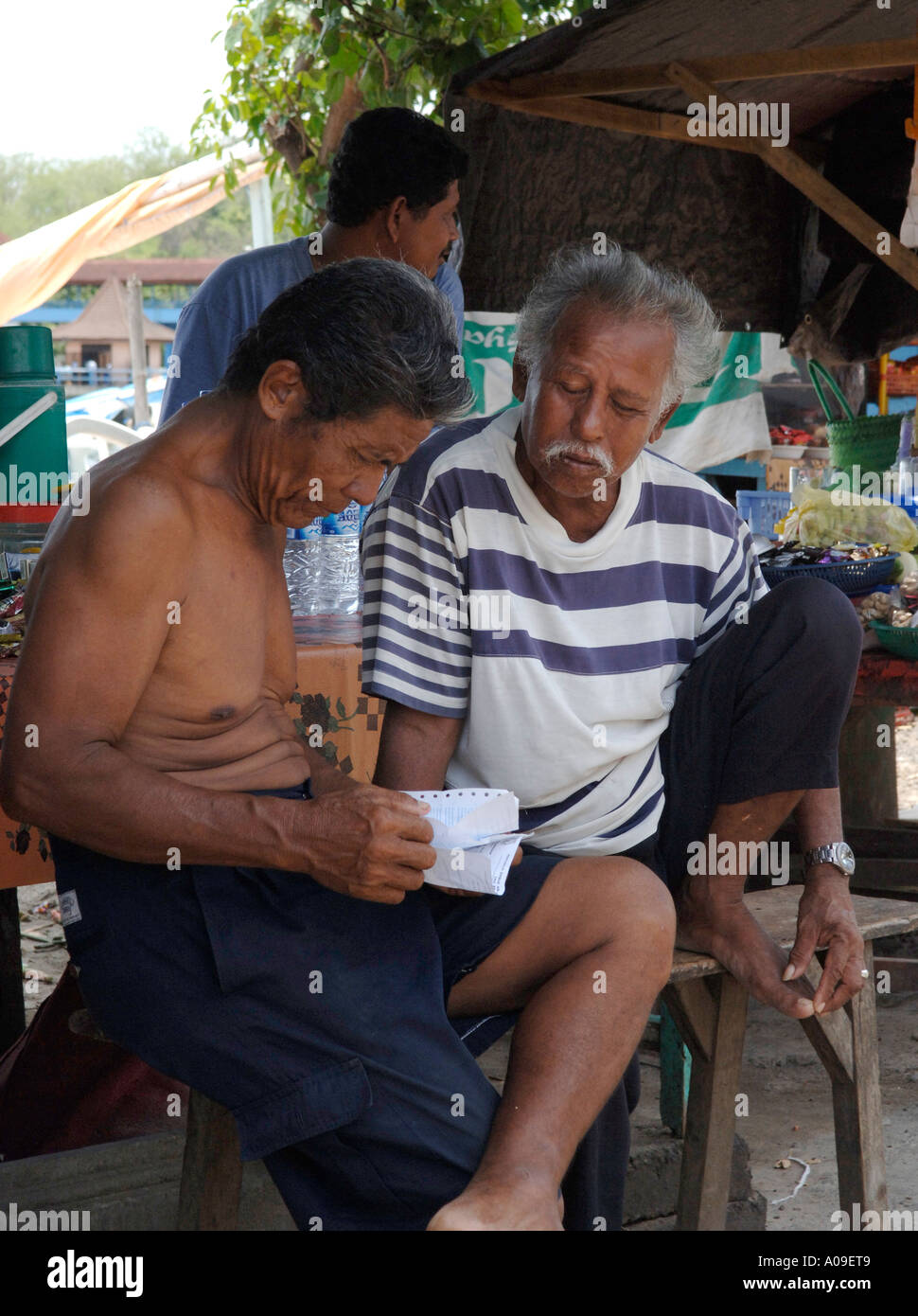 Two local Indonesian men sitting together, Bali street market Stock ...